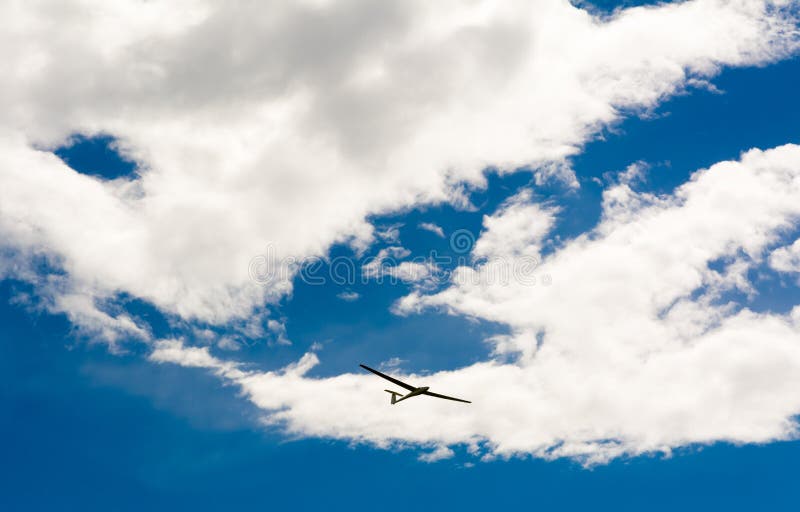 A Glider Flying in Bleu Sky with Big White Clouds. the Glider is a ...