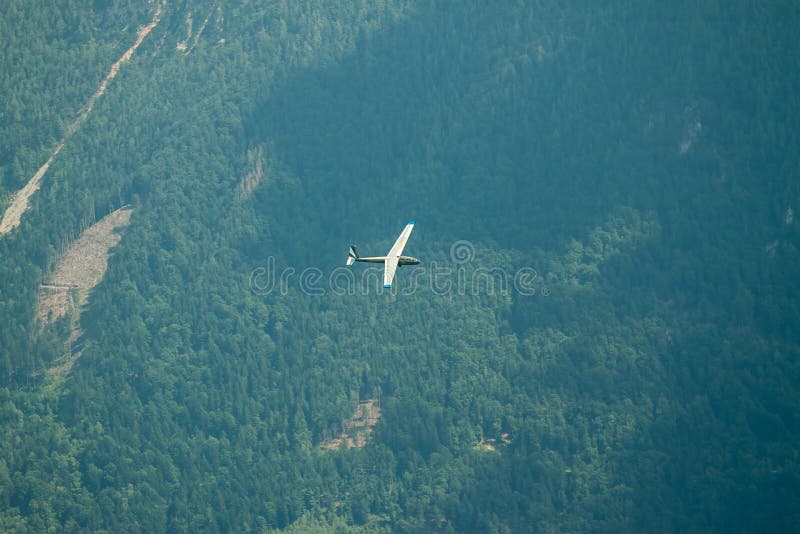 Glider flying over forest stock photo. Image of airplane - 95850916
