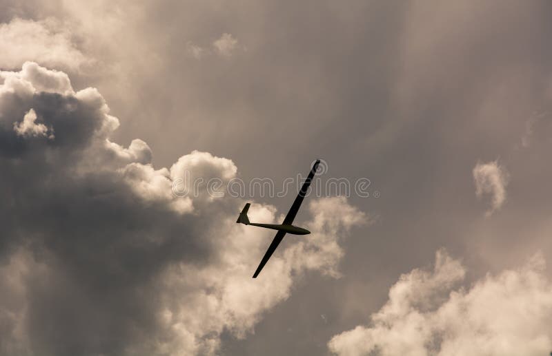 A Glider Flying in Sky with Big Threatening Clouds. the Glider is a ...