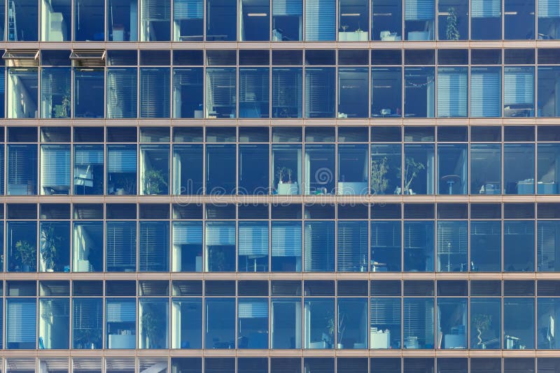 Glimpse into the Workplaces of an Office Building with Blue Glass ...
