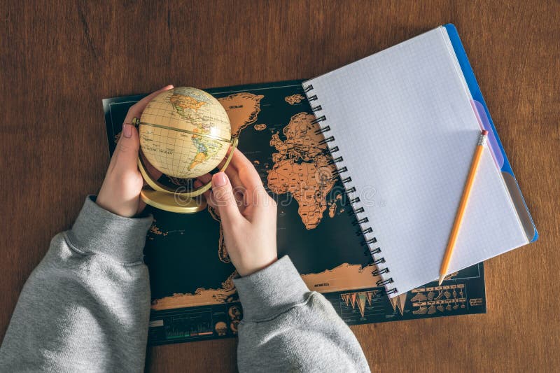 Globe in Female Hands, Empty Notepad and World Map on a Wooden Table ...