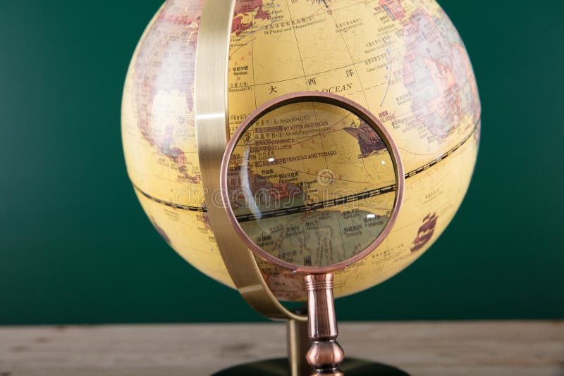 A Globe and a Magnifying Glass in Front of a Blackboard Stock Photo ...