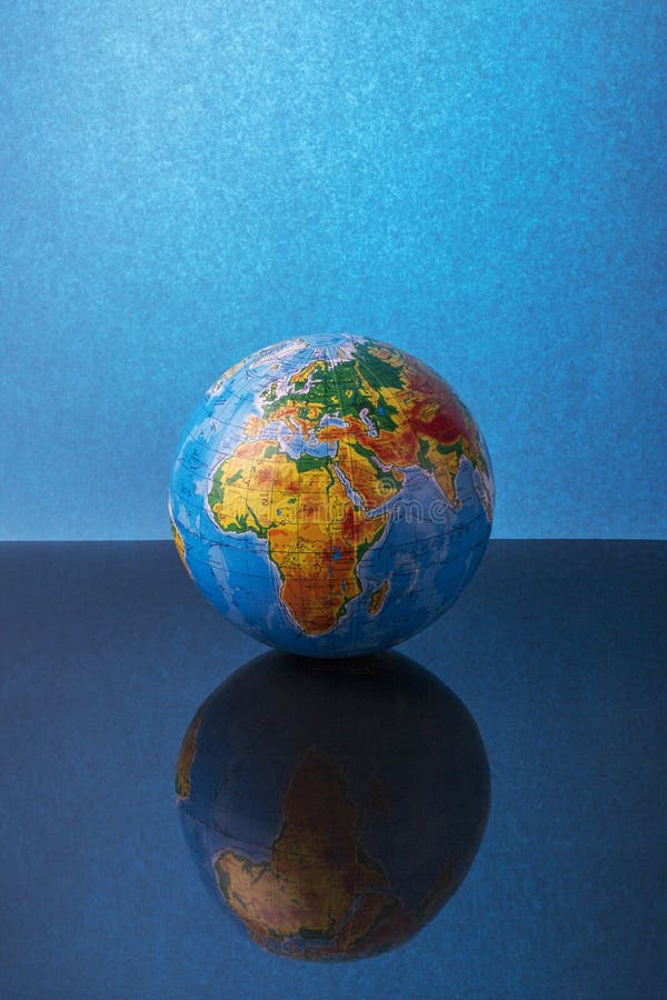 Globe on a Reflective Surface on a Blue Background. Stock Image - Image ...