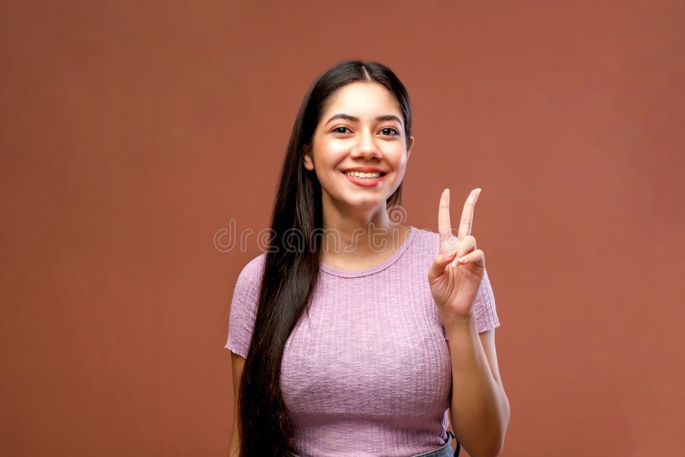 A Glorious Model is Smiling and Making a Victory Hand Sign while Posing ...