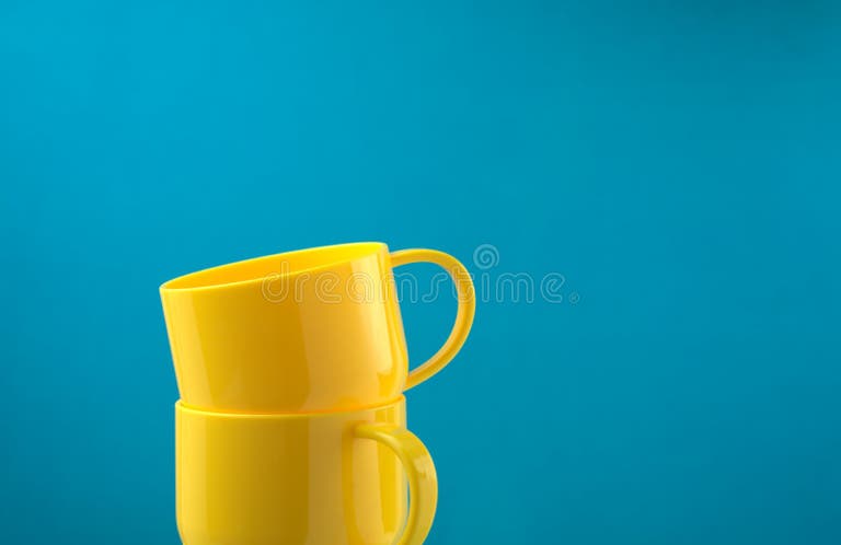 Glossy Yellow Colored Cups Stacking on Blue Background. Off-center ...