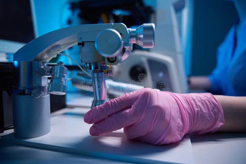 Gloved Hand Adjusting a Micromanipulator Under a Microscope in ...