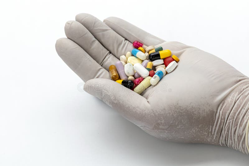 A Gloved Hand Offers a Kaleidoscope of Pills, Capsules, and Tablets ...
