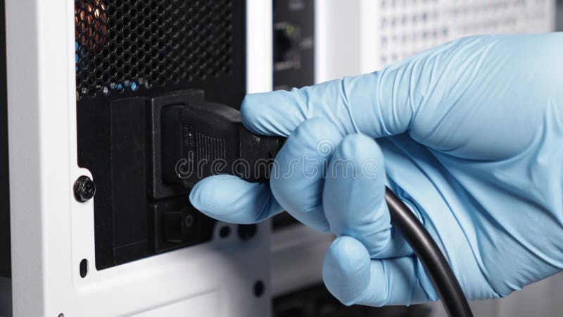 Gloved Hand Plugging Power Cable into PSU Socket on the Back of White ...