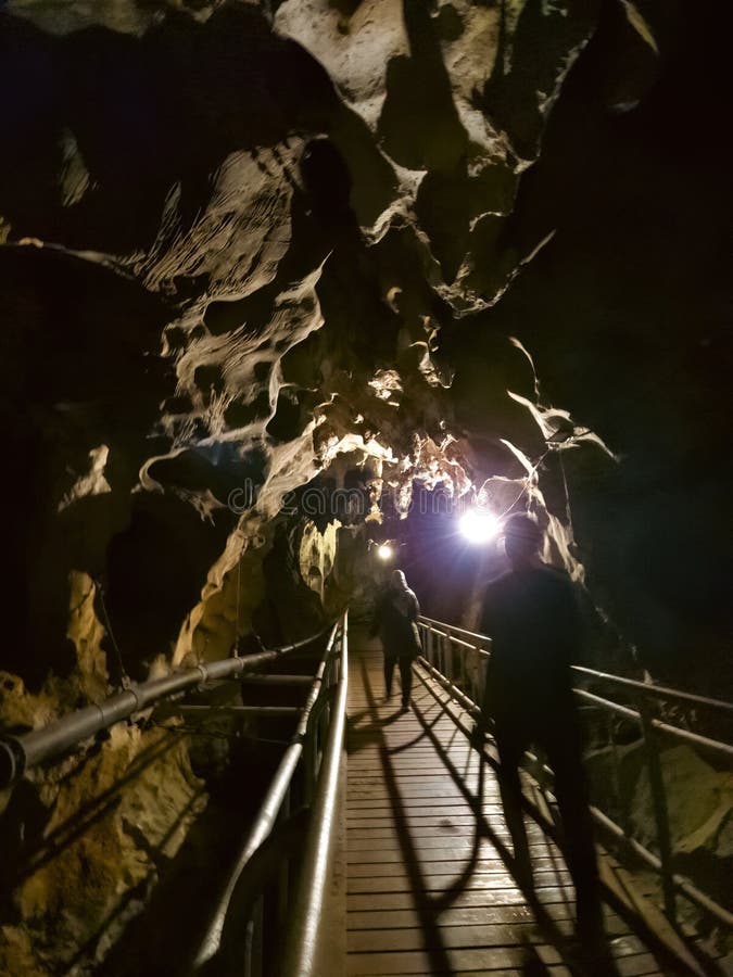 Glowing Tourists Exiting the Cave with Walking Tourists Inside the ...