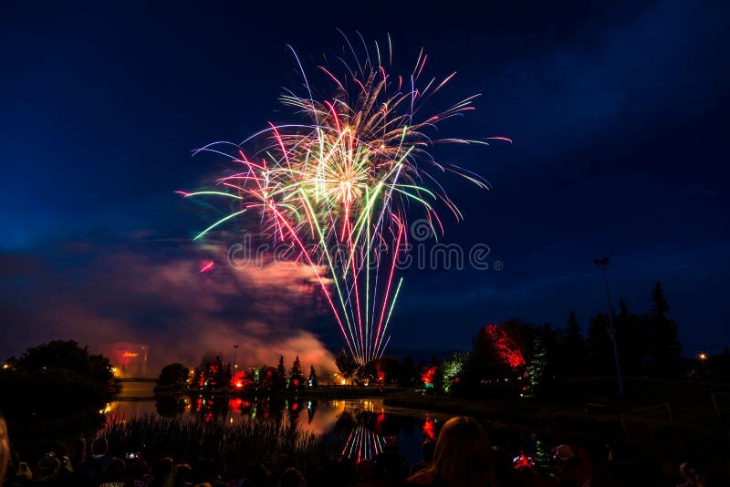 Glowing Fireworks Illuminating the Night Sky with People Watching - the ...