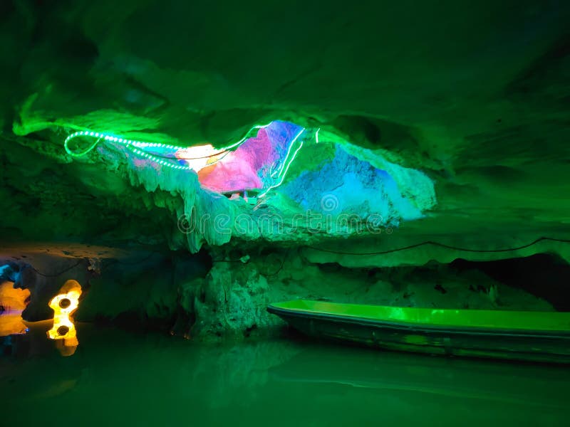 Glowing Green Cave with Multiple Colored Lights, Small Boat in the ...