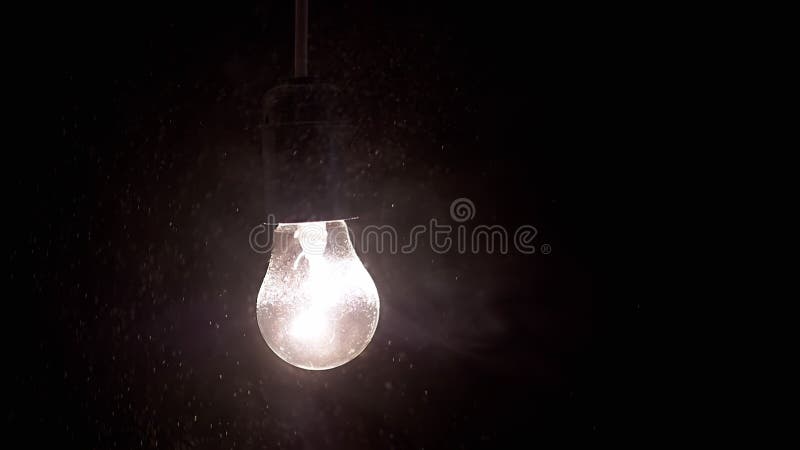 Glowing Light Bulb Illuminates the Falling Snow in a Thick Fog in the ...