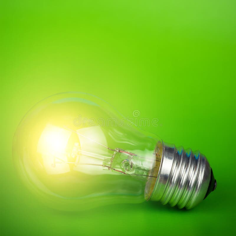Glowing Light Bulb Over Green Background Stock Photo - Image of ...