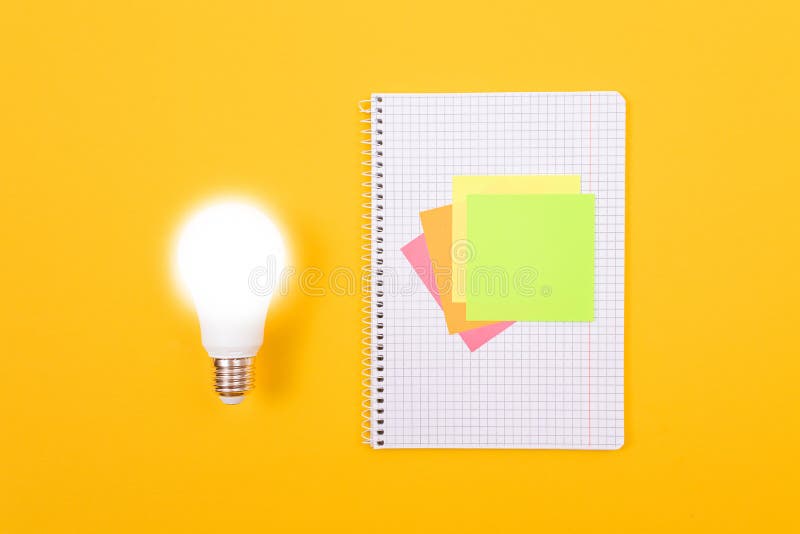 Glowing Power Saving Lamp and a Notepad with Sticky Notes Stock Photo ...