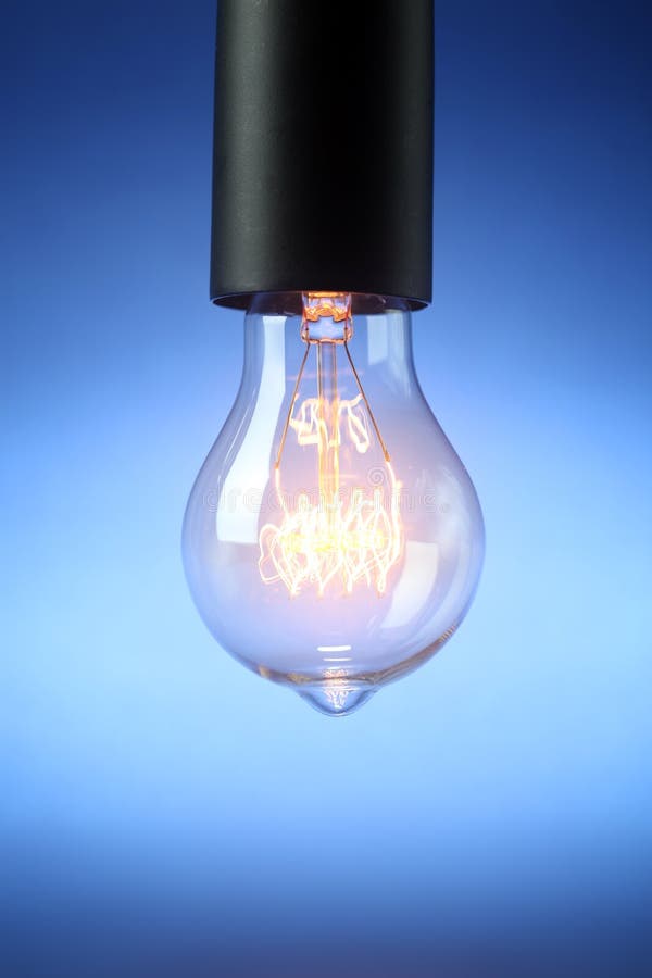 Vintage Old Light Bulb Glowing on Rough Dark Background Surrounded by ...