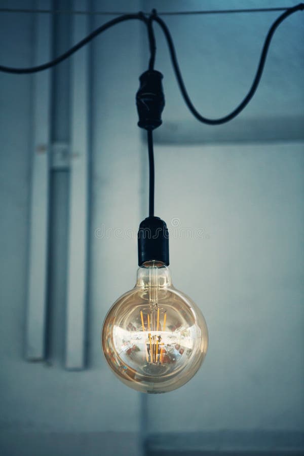 Glowing Vintage Light Bulb on Blue Wall Background. Vertical Image ...