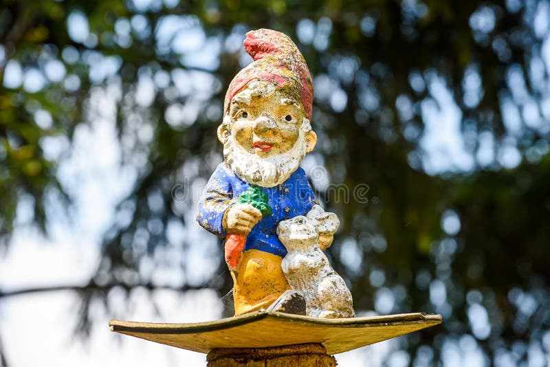 A Gnome Dwarf Statue in the Garden Stock Photo - Image of flower, humor ...