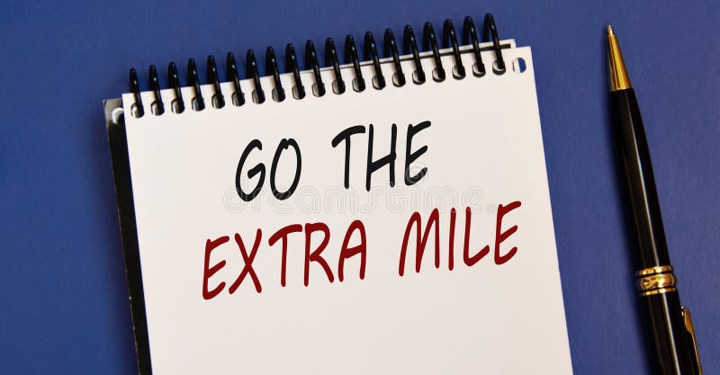 GO the EXTRA MILE - Word in a White Notebook on a Blue Background with ...