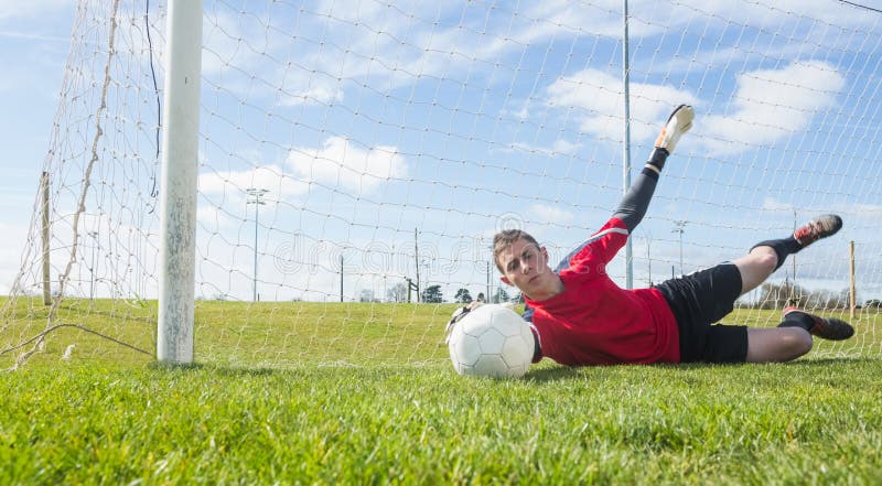 Goalkeeper in Red Making a Save Stock Image - Image of sport, green ...