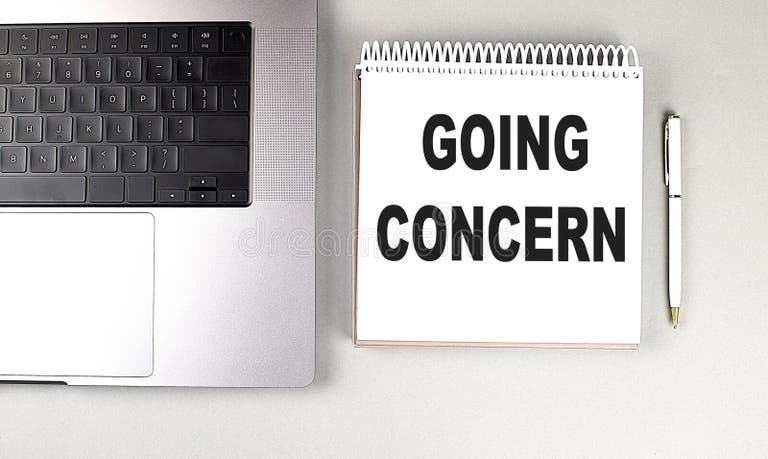 GOING CONCERN Text on Notebook with Laptop and Pen Stock Photo - Image ...