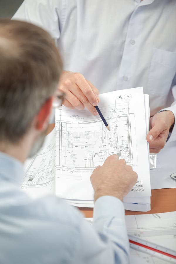 Going over building plans stock image. Image of decide - 83783907