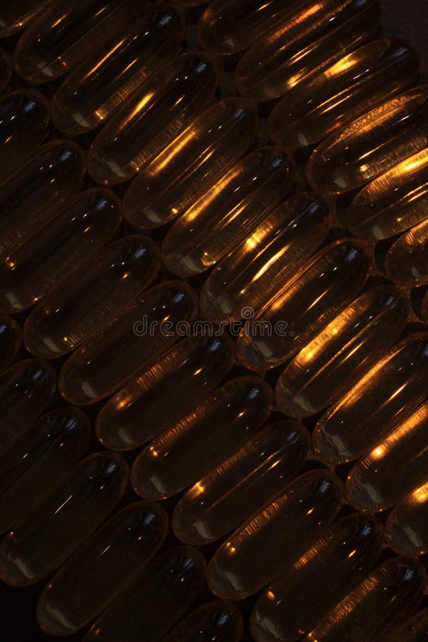 Gold Capsules Under Contrast Lighting Stock Photo - Image of heap ...