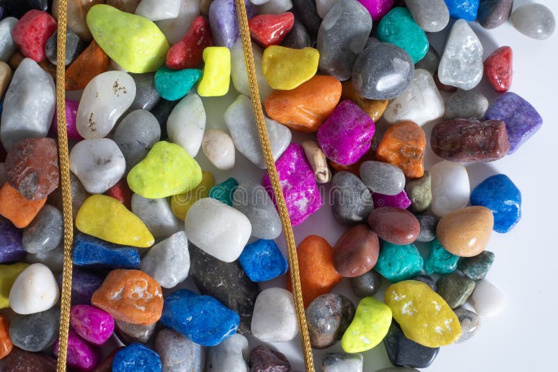 Gold Chain on Top of Different Colored Stones on White Background Stock ...