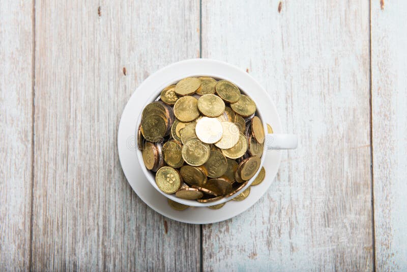Gold coins on a coffee cup stock photo. Image of consumer - 67631332