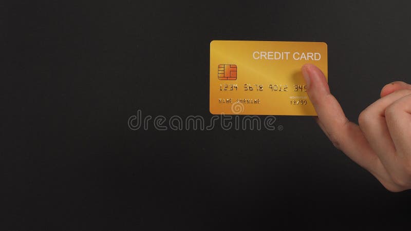 Gold Color Credit Card in Hand on Black Background Stock Image - Image ...