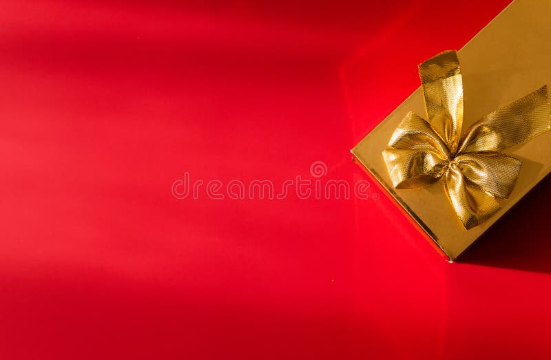 Gold Color Gift Wrap with Gold Bow on Red Background Stock Photo ...