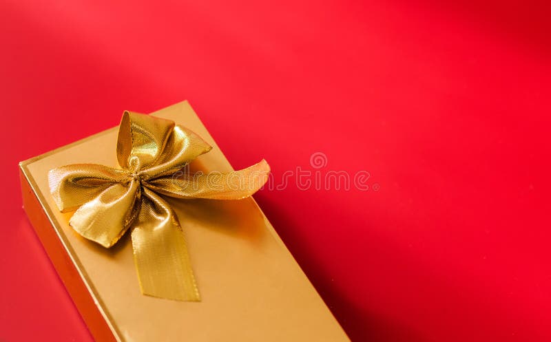 Gold Color Gift Wrap with Gold Bow on Red Background Stock Photo ...