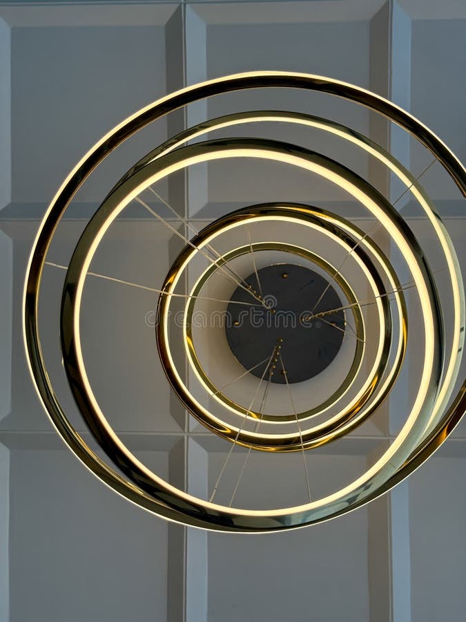 A Gold Colored Light Fixture with a Clock on it Hangs from the Ceiling ...