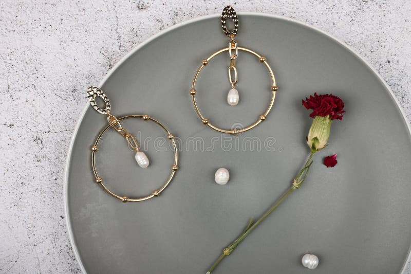 Gold earrings in a plate stock photo. Image of blush - 182452330