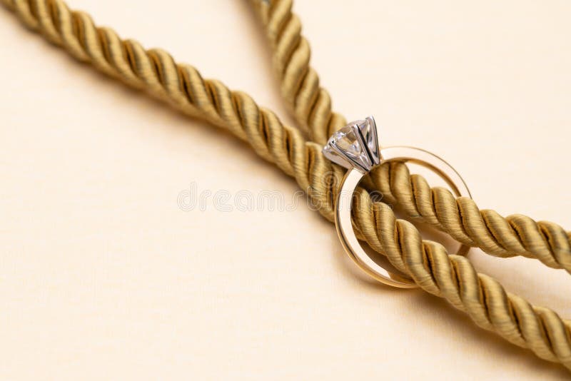 Gold Engagement Diamond Ring on Ropes with Knot Stock Image - Image of ...