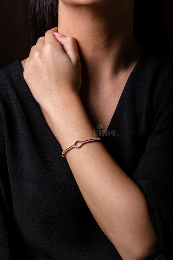 Gold Female Bracelet on Hand with Shape of Ovals and Stones on a Black ...