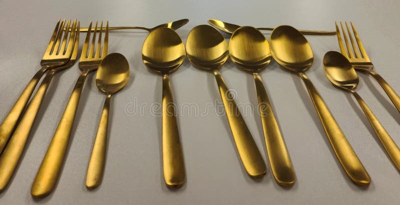 Gold Plated Cutlery at Kitchen Table with Light Reflections Stock Image - Image of alignment ...