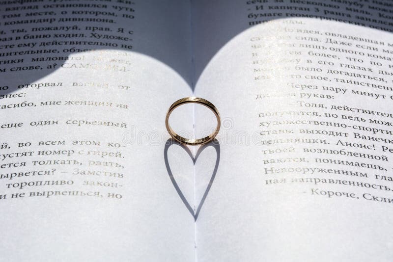 Gold Ring in the Centre of Book with the Heart Shape Shadow Stock Image ...