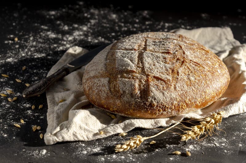 Gold Round Loaf of Rustic Bread and Ears of Wheat. Black Background ...