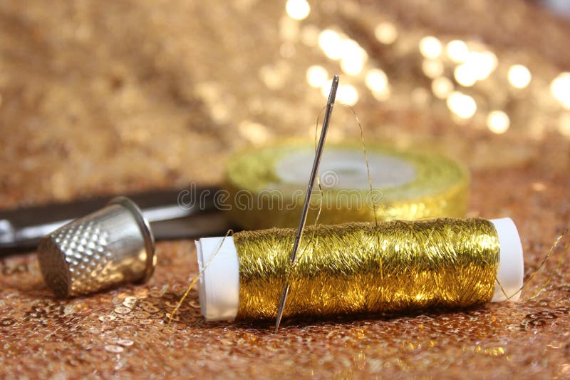 Gold Sequins on Fabric with Spool of Gold Metallic Thread and Thimble ...