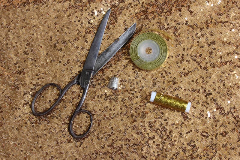 Gold Sequins on Fabric with Spool of Gold Metallic Thread and Thimble ...