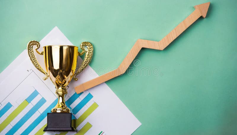 Gold Trophy on Top of Financial Graphs with an Arrow Pointing Up Stock ...