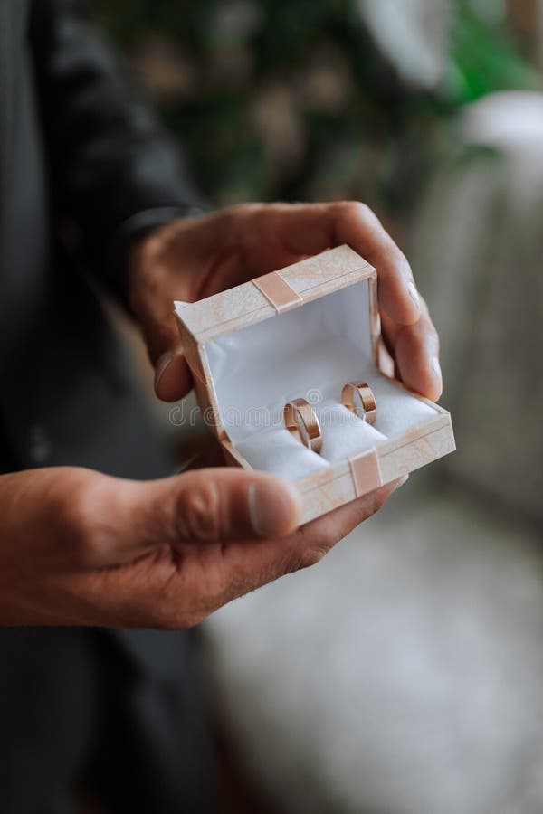 Gold Wedding Rings in a Box in the Hands of the Groom Close-up Stock ...