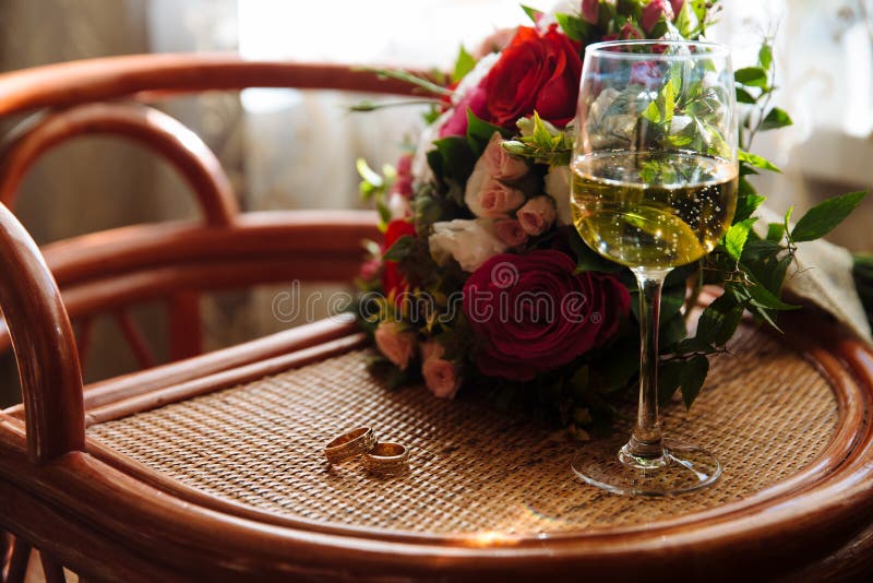 Gold Wedding Rings, a Glass of Champagne, Bouquet on the Table Stock ...