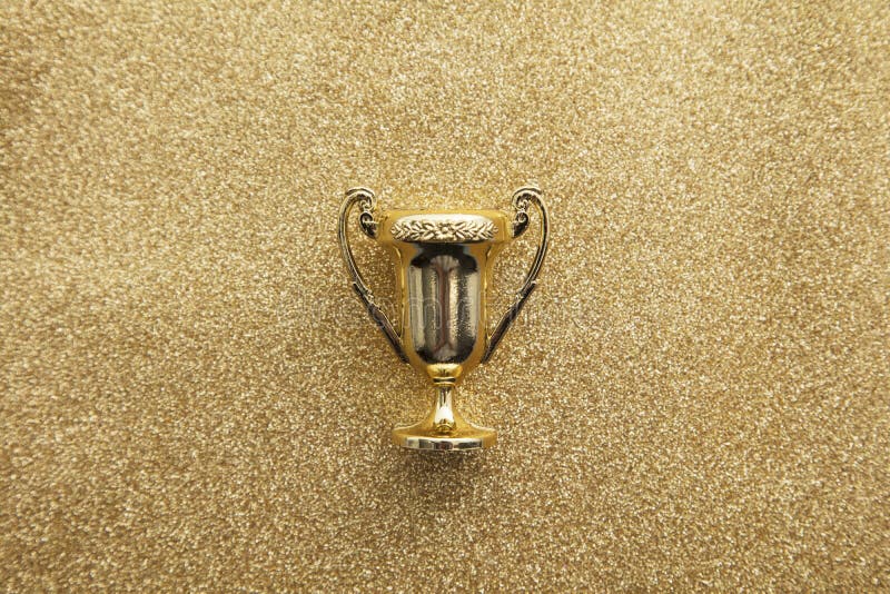 Gold Winners Achievement Trophy on a Gold Glitter Background Stock ...