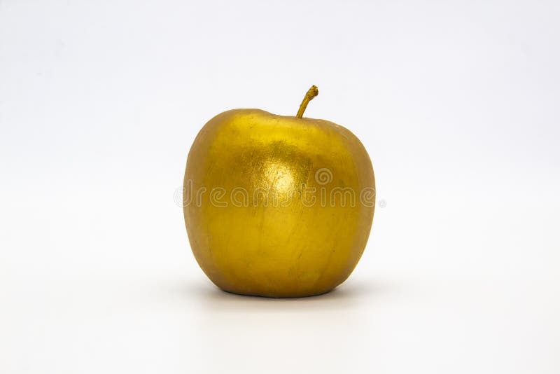 A Golden Apple on a White Background. Concept in Design Stock Photo ...