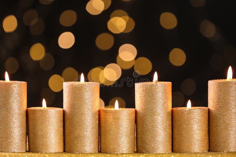 Golden Candles Burning on Table Against Defocused Lights Stock Image ...