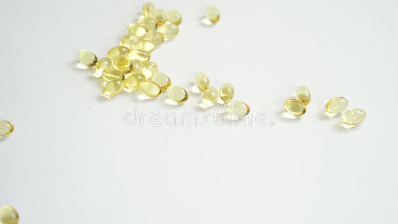 Golden Capsules Pouring in Sequence on White Surface Health Supplement ...