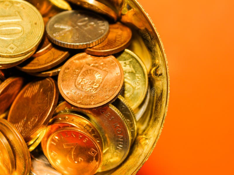 Golden Copper and Silver Coins in a Cup with Orange Background Stock ...