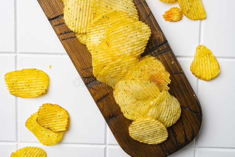 Golden Corrugated Potato Chips on White Ceramic Squared Tile Table ...