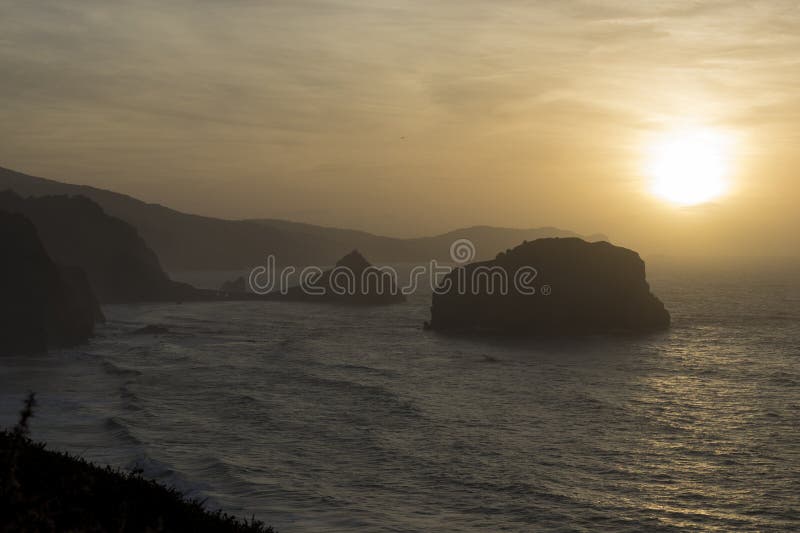 Golden Hour Brilliance: a Sunset Over the Ocean with Rocky Cliffs ...